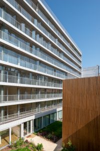 Un immeuble paré de verre abritant un cœur d'îlot végétalisé au 118-122 ...